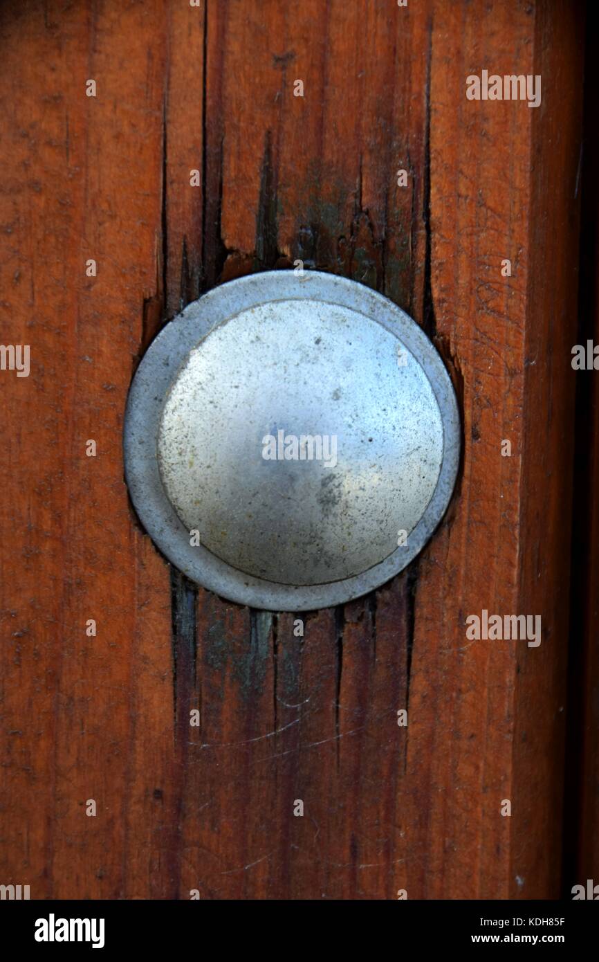 stainless steel metal bolts in wooden door, close-up of metal bolt with ...