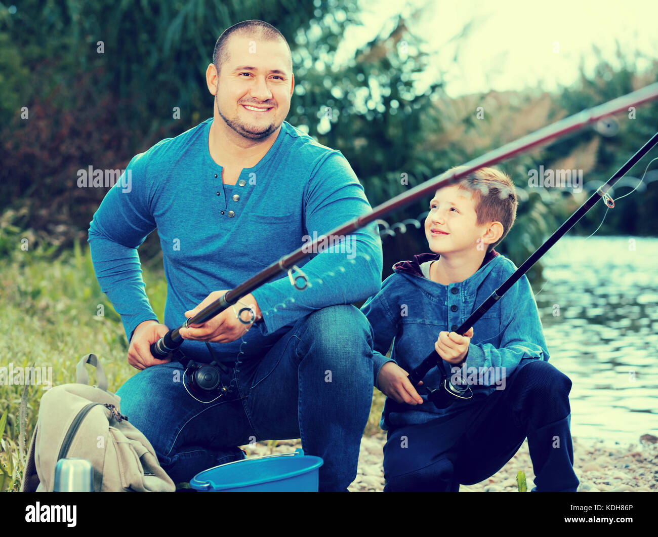 Glad father and boy fishing with rods in summer day Stock Photo - Alamy