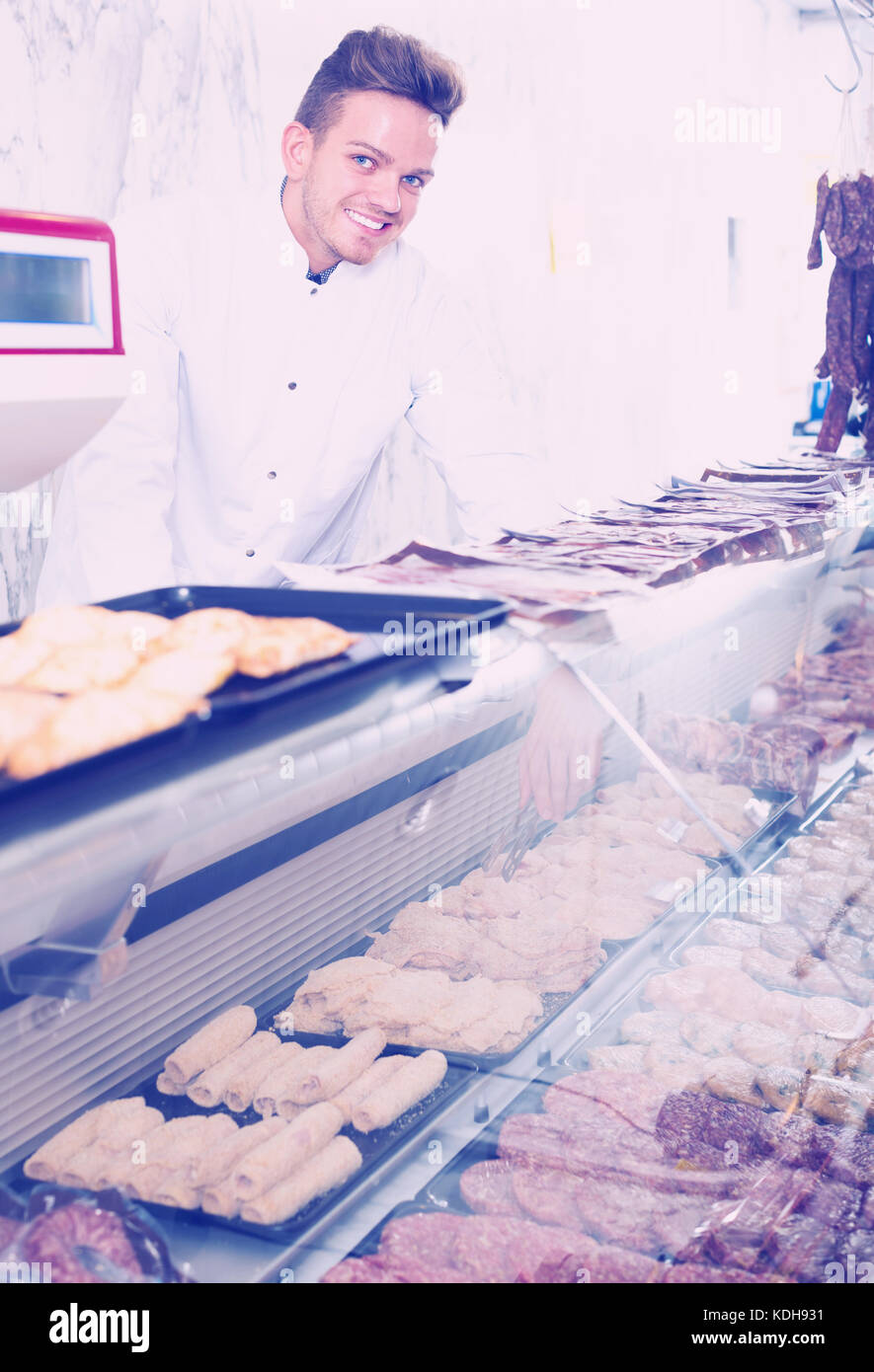 Happy young ordinary man seller working at meat market Stock Photo - Alamy