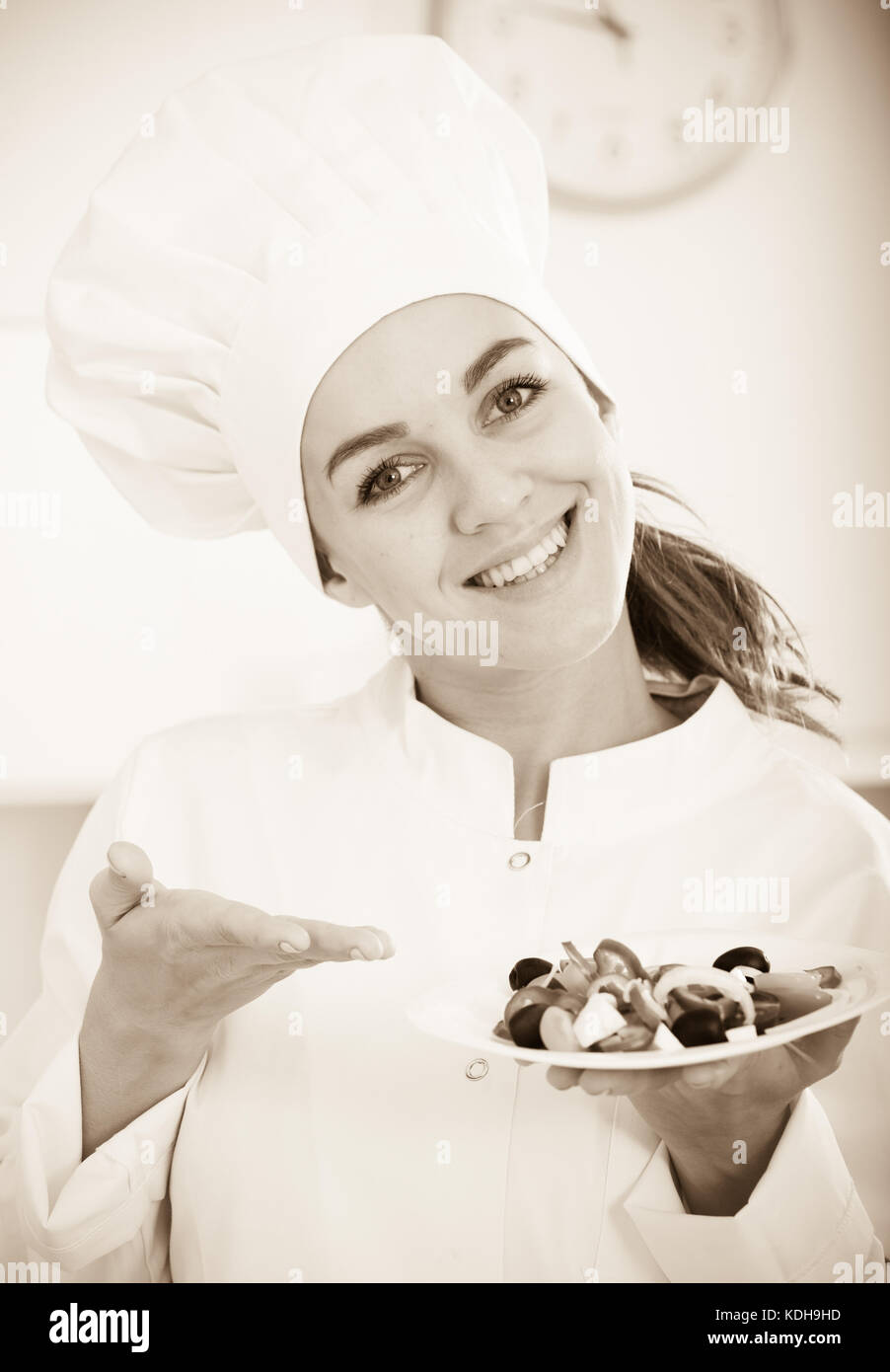 smiling girl cook with chestnut hair shows plate of salad Stock Photo ...