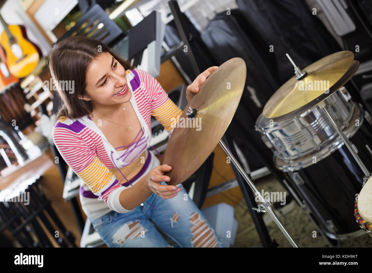 Happy teenage girl shopping drum kit in music instruments studio Stock ...