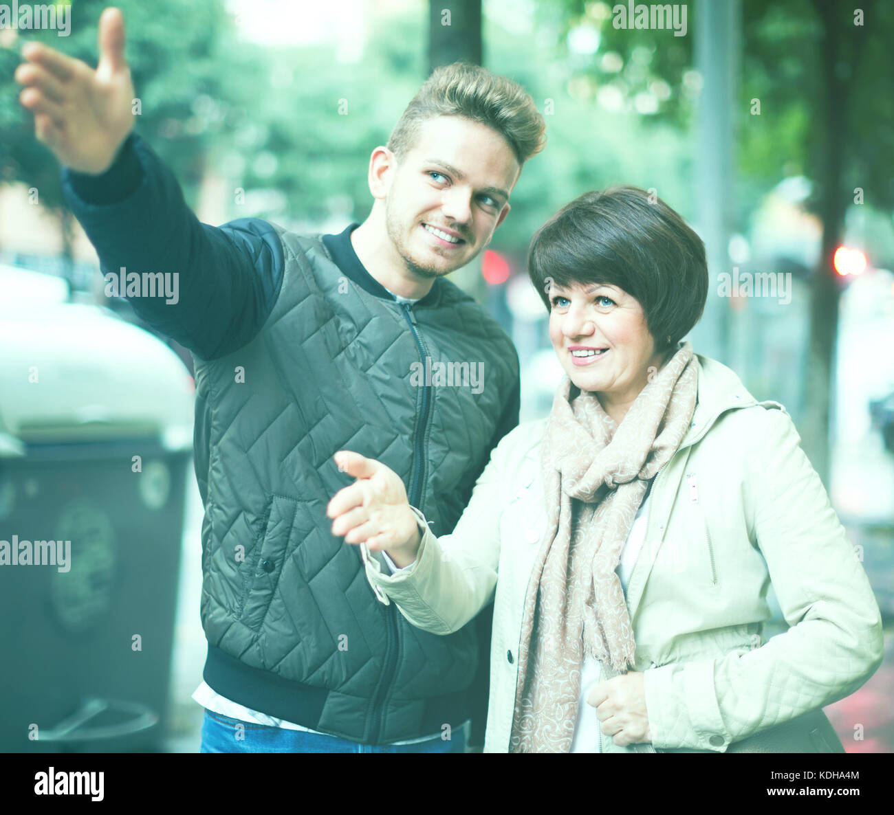 Young man points the direction to woman outdoor Stock Photo - Alamy