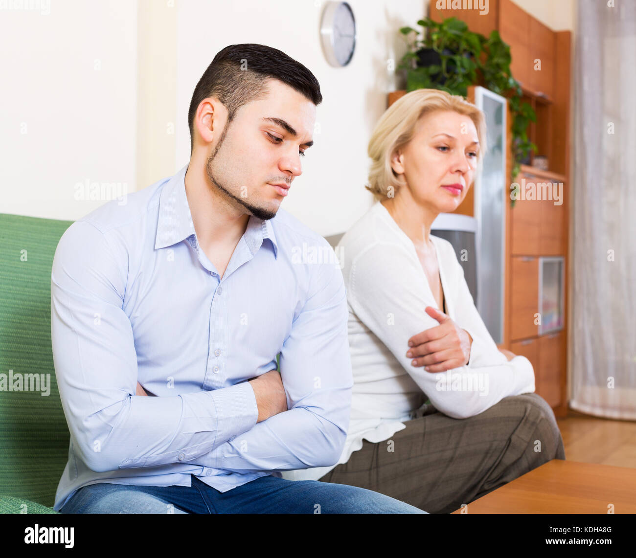 Sad mature woman explaining something to offended young man Stock Photo ...