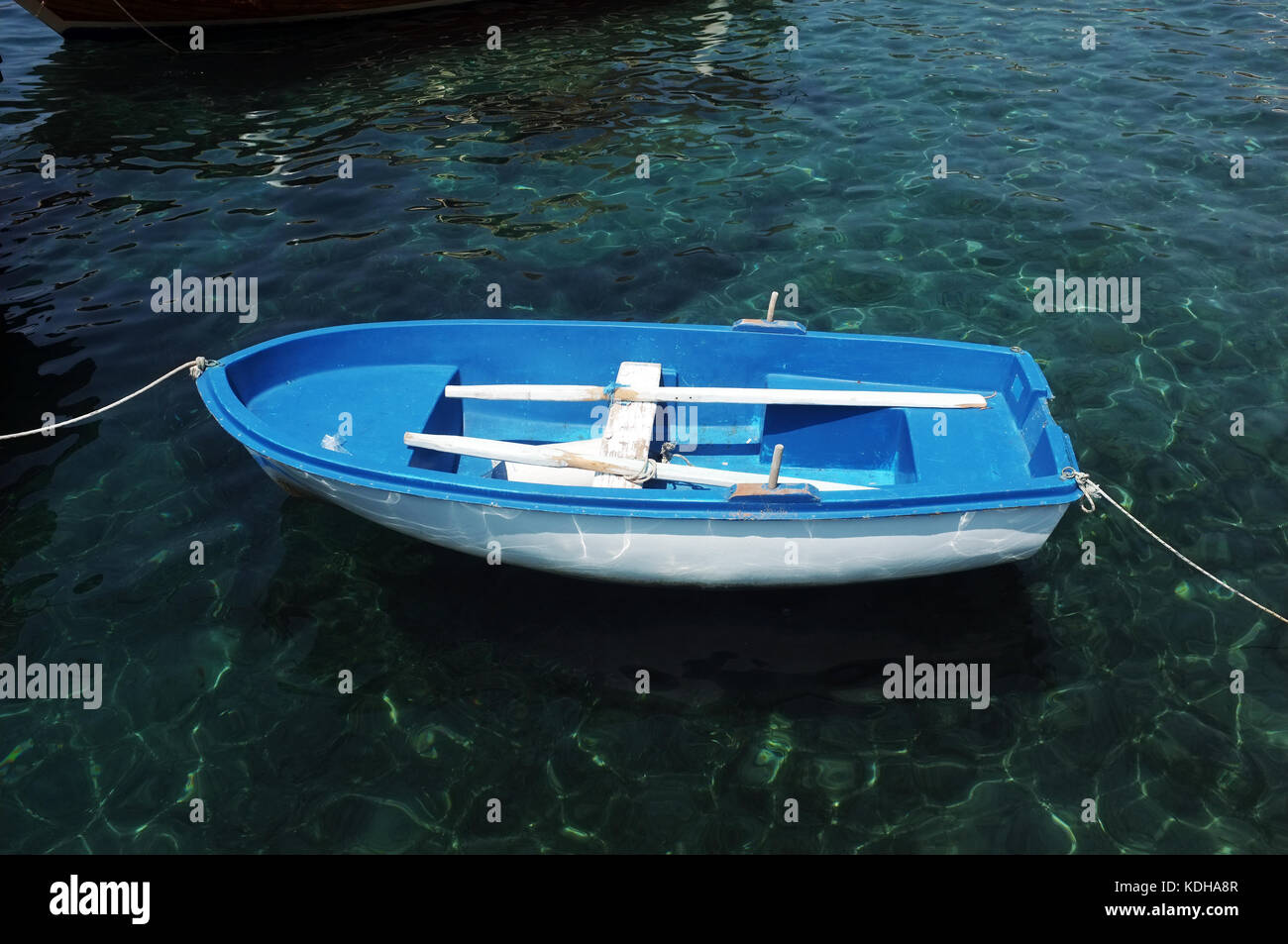 Blue small boat floating on water Stock Photo - Alamy