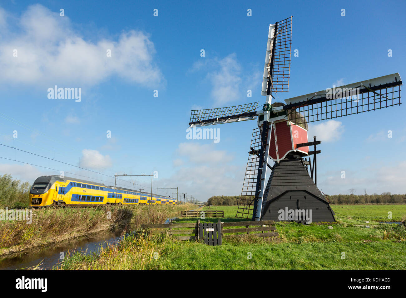 Dutch passengertrain passing a windmill, typical dutch landscape Stock ...