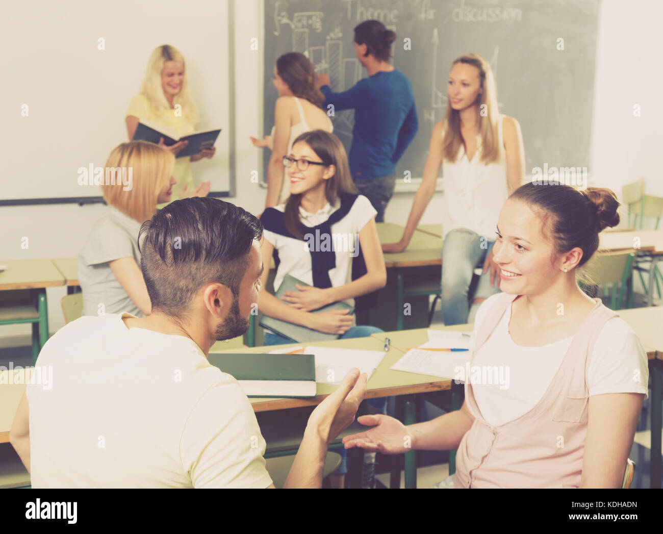 Friendly adult students chatting while sitting in the school Stock ...