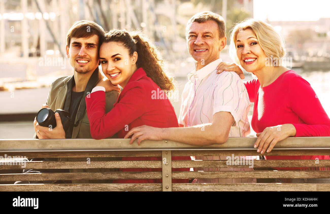 Portrait of smiling spanish young and mature couple sitting on ...