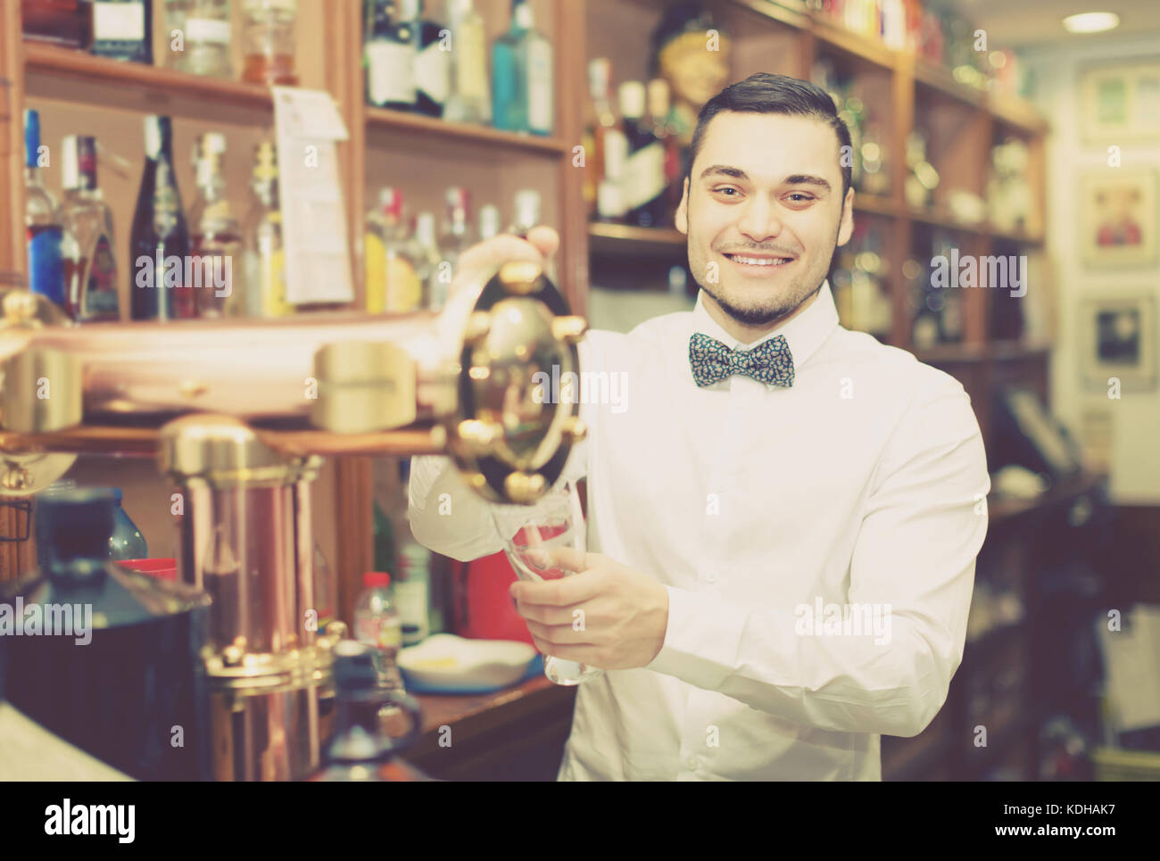 Modern bar with bottles at background and happy smiling male bartender ...