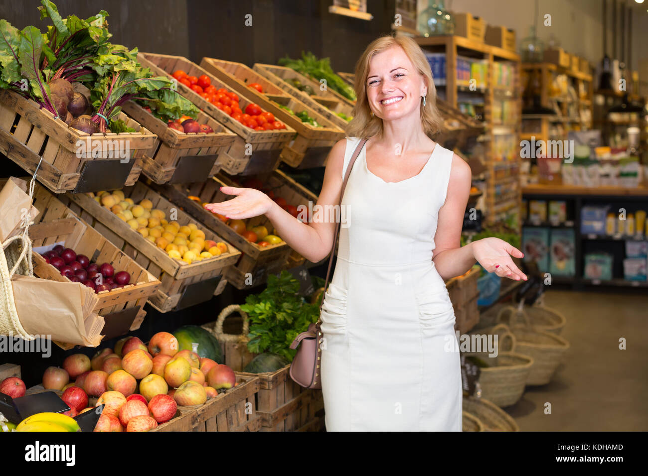 joyful smiling female customer choosing fresh vegetables and fruits in ...