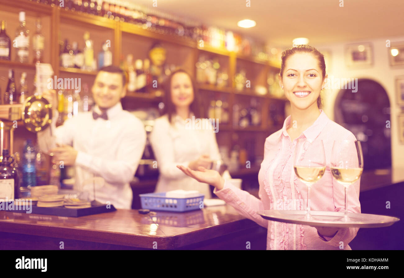 Positive brunette waitress and barmen working in modern bar Stock Photo ...