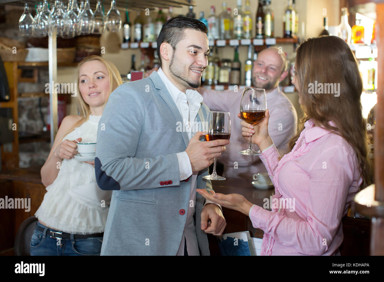 Positive bartender entertaining guests at a bar counter in bar Stock ...