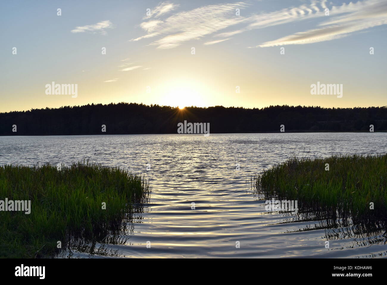 Beautiful landscape with sunset over the forest lake. Calm weather ...