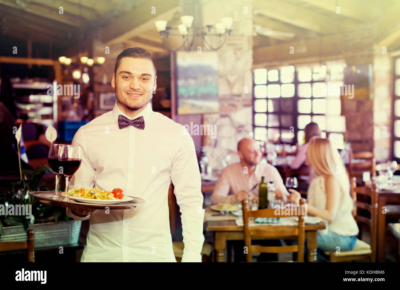 Portrait of adults having dinner and respectful waiter Stock Photo - Alamy