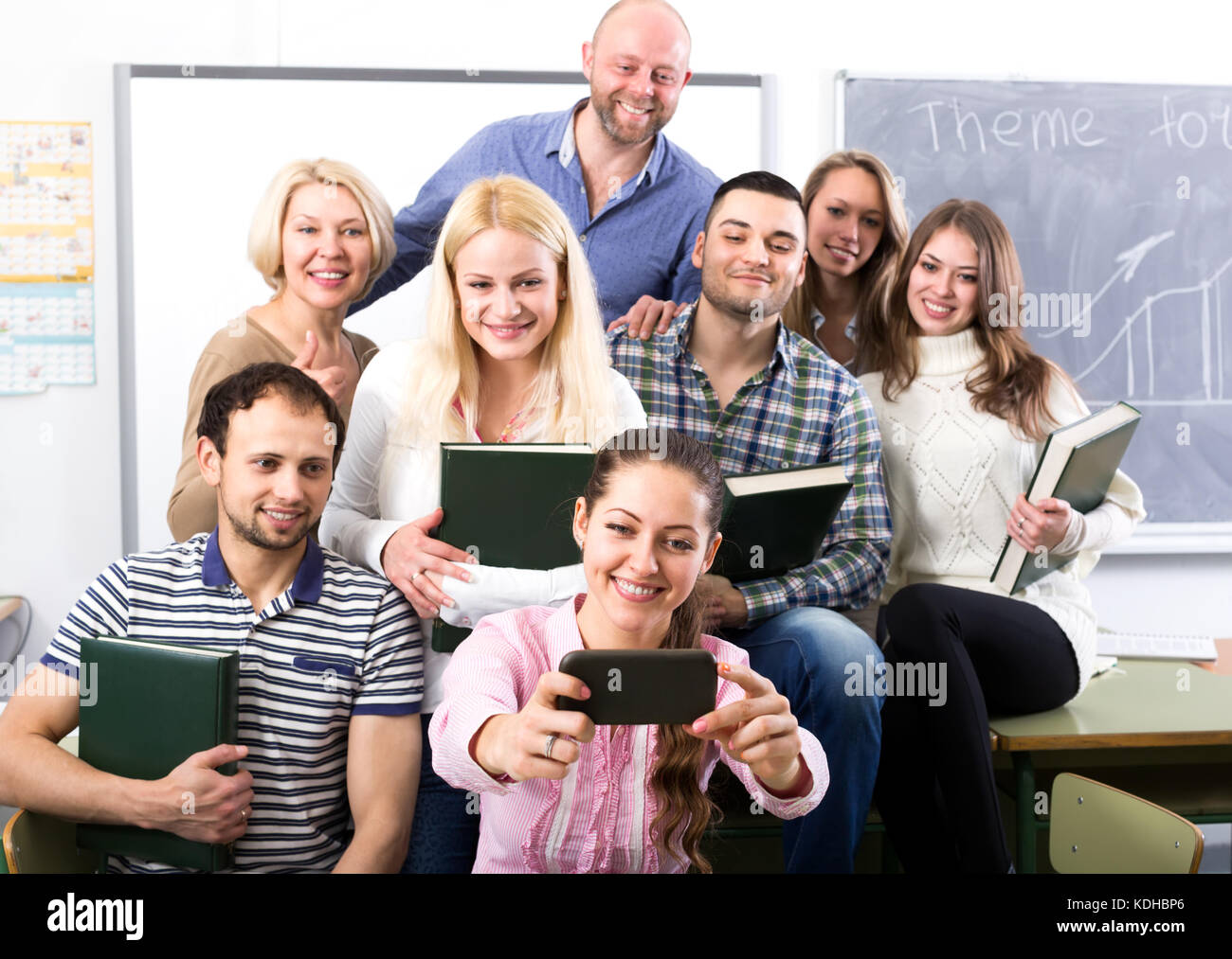 Students taking a selfie with their teacher in classroom during a break ...