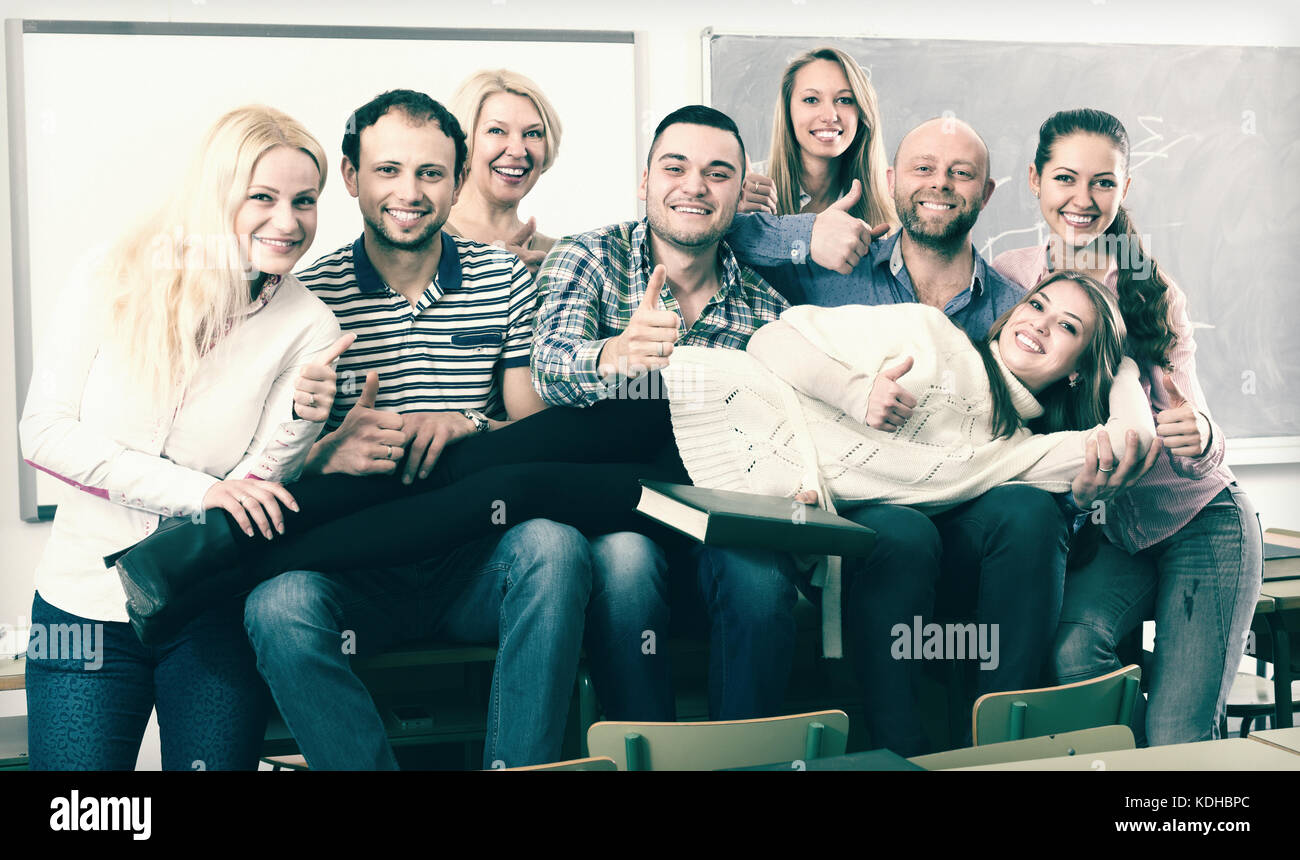 Happy female professor and cheerful students posing in classroom at ...