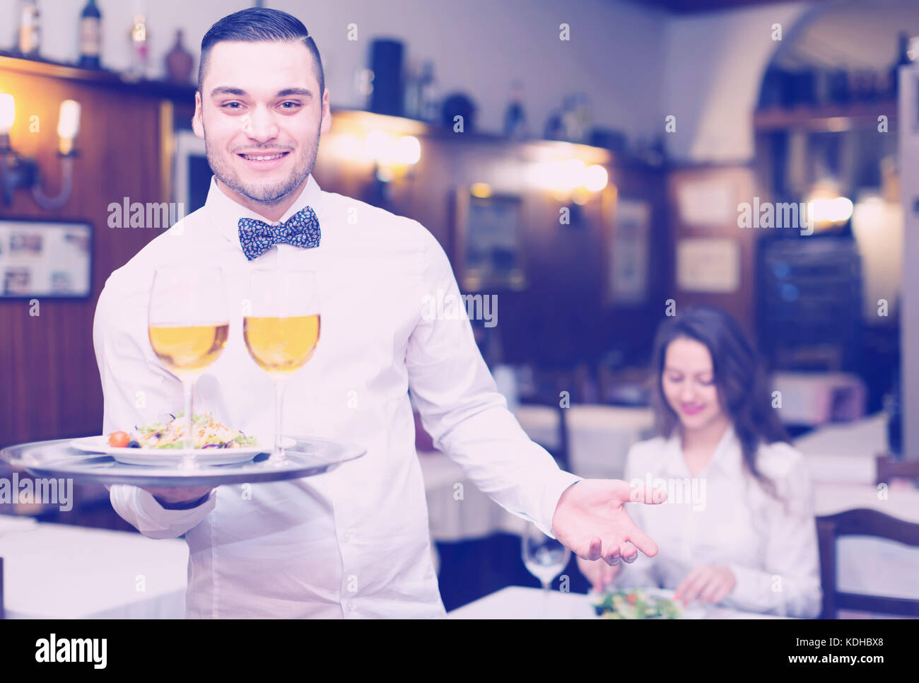 Waiter with prepared meal at attendee table Stock Photo - Alamy