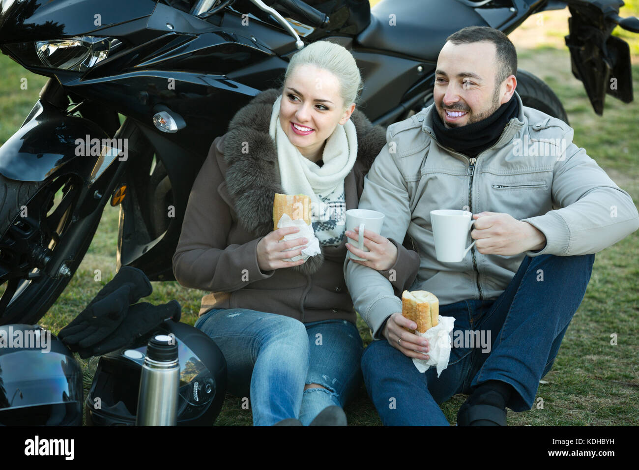 young adults drinking coffee and chatting near motorcycle Stock Photo ...