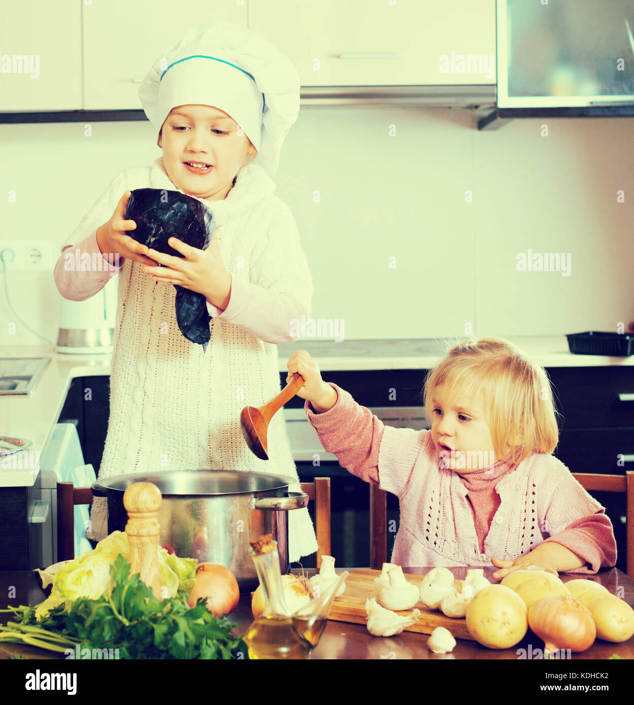 Mama's daughter learning to cook soup on kitchen table Stock Photo - Alamy