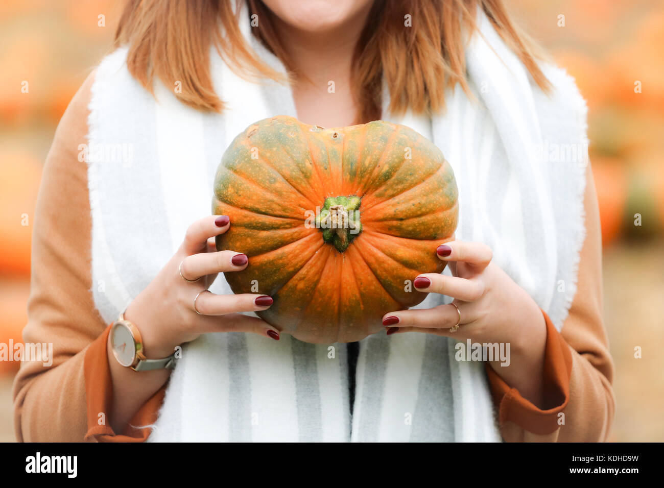 Women dressed in autumnal fashion holding heart shaped pumpkin at a ...