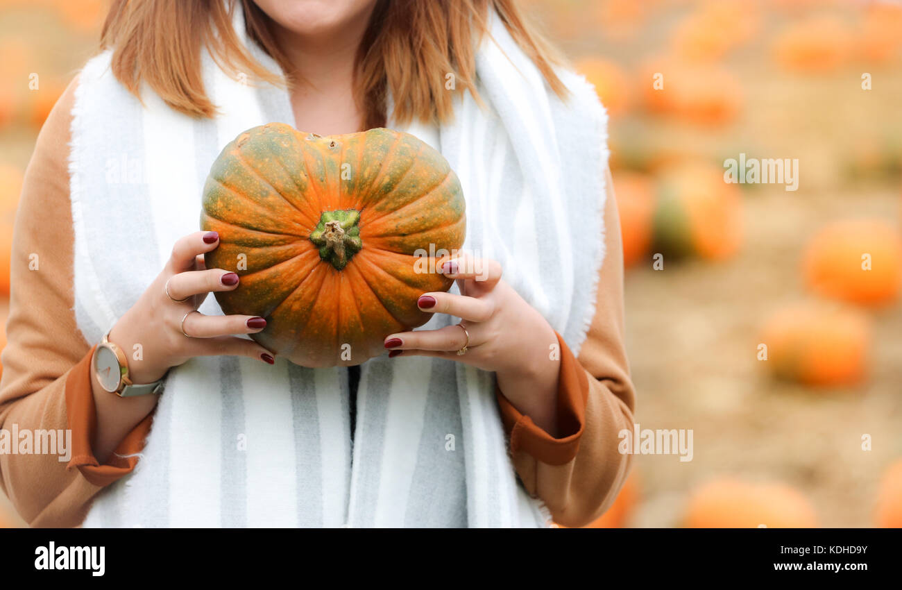 Women dressed in autumnal fashion holding heart shaped pumpkin at a ...