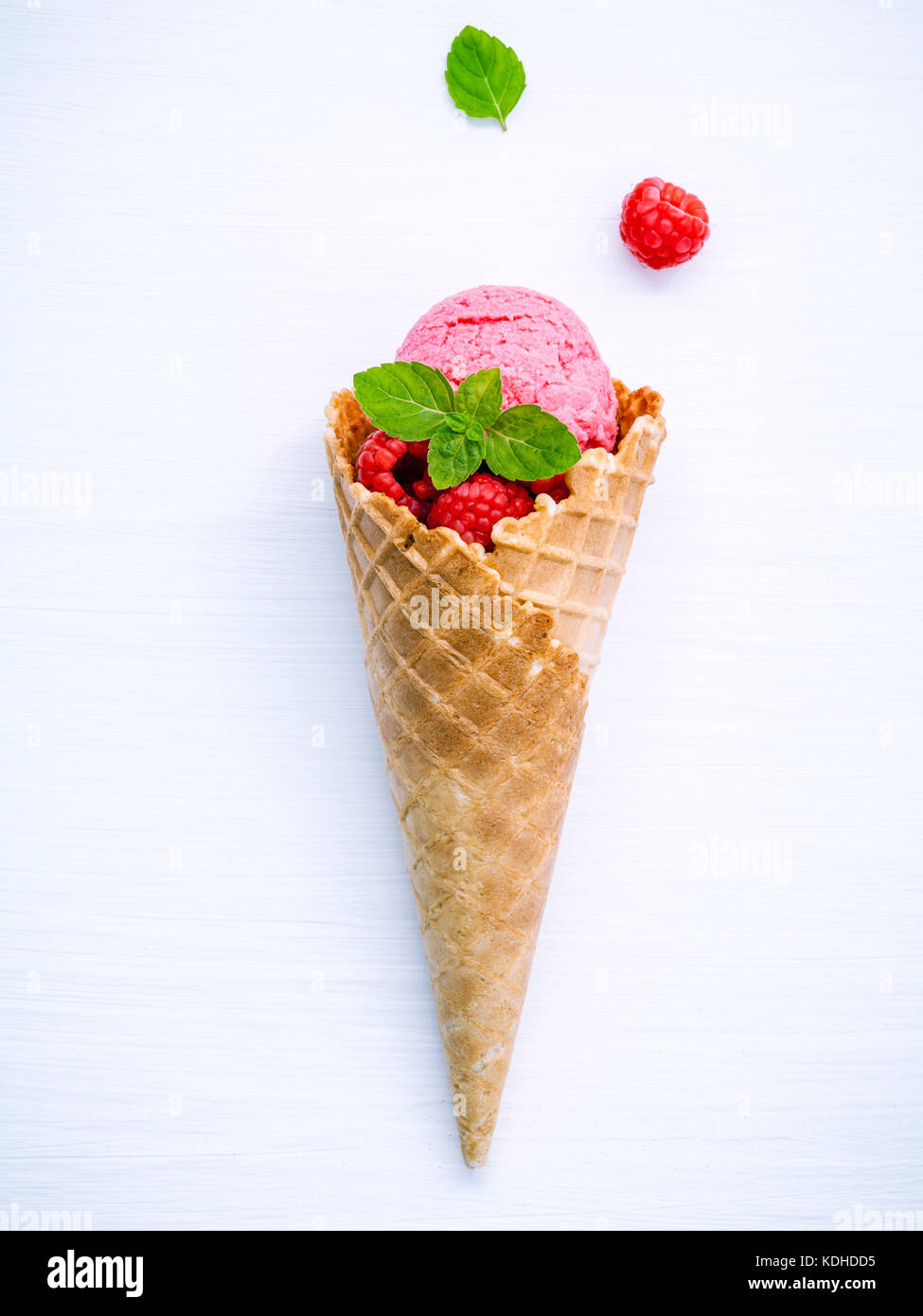 Raspberry ice cream in cone with fresh raspberry and peppermint leaves ...