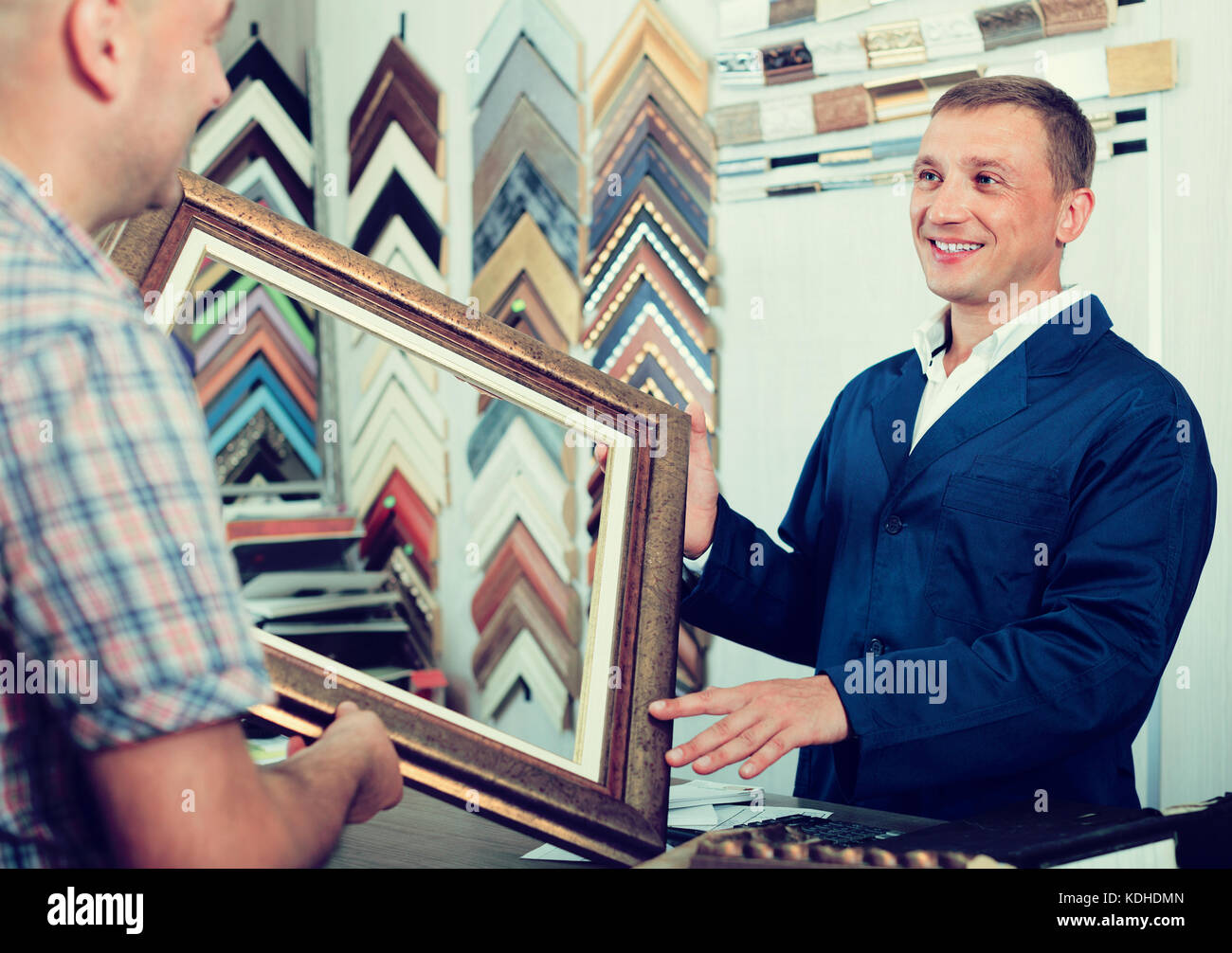 friendly smiling man worker chatting with customer about picture frame ...