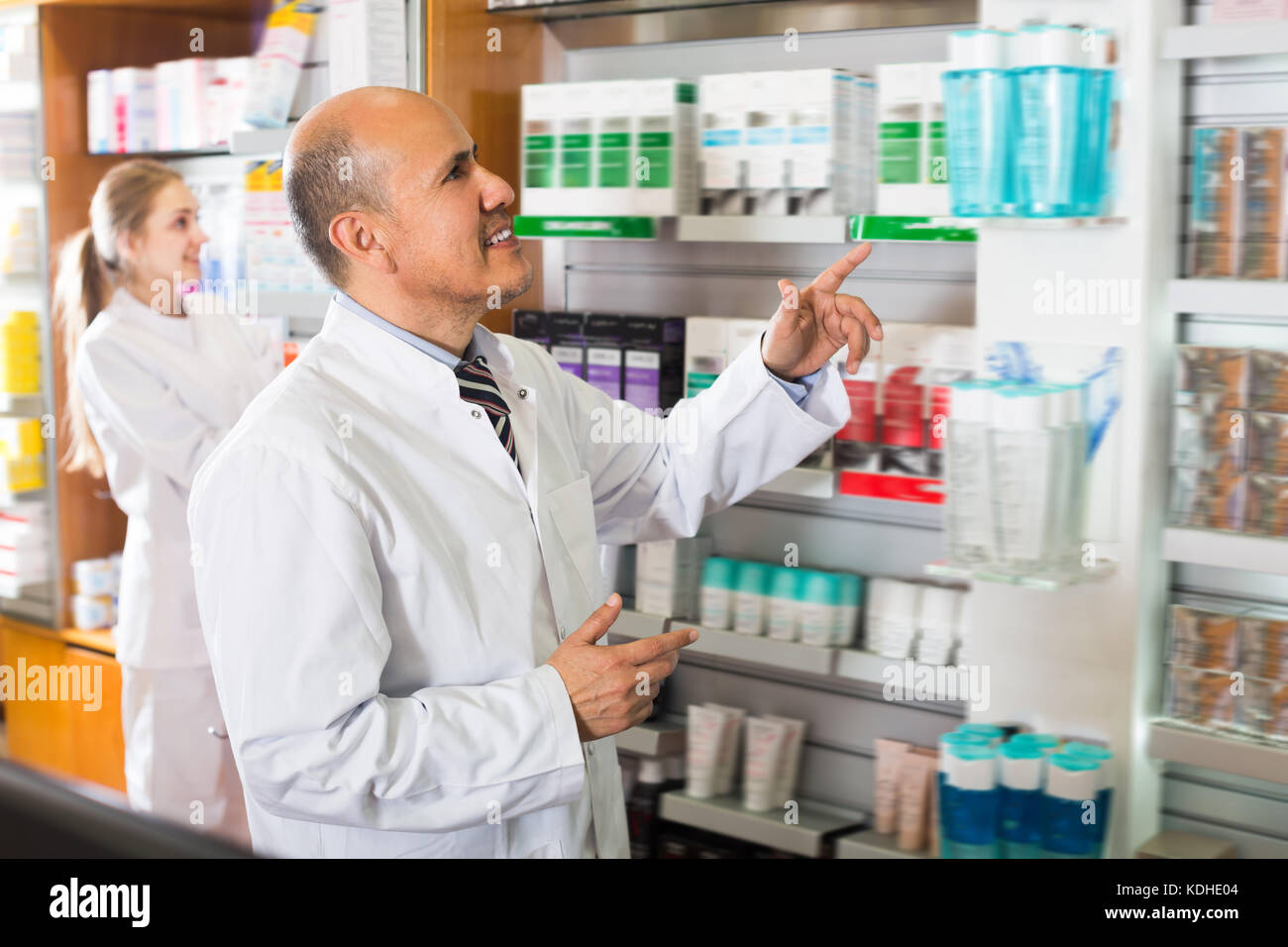 Pharmacist and pharmacy assistant helping in drugstore Stock Photo - Alamy