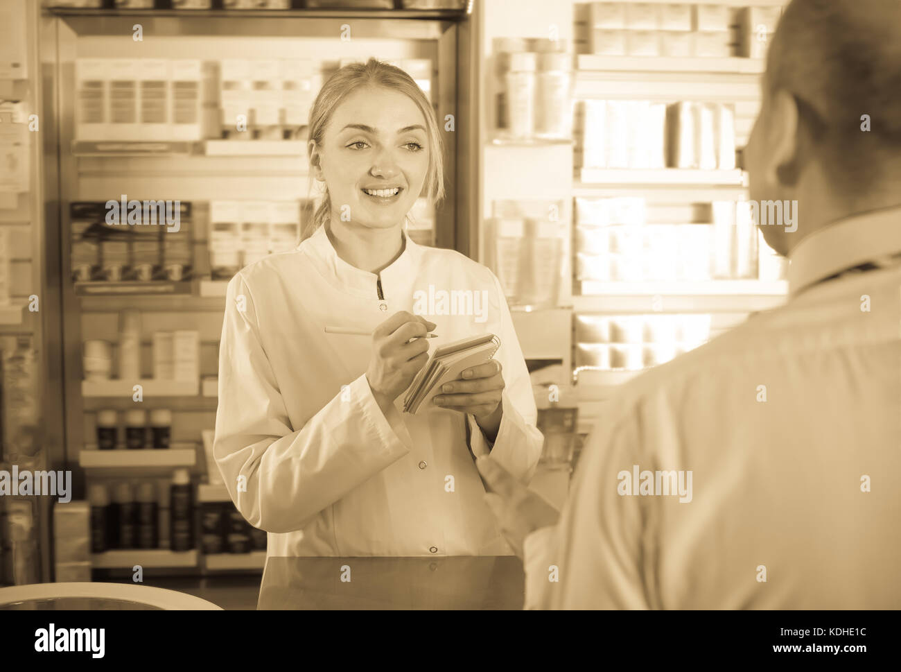 Female pharmaceutist in drugstore helping man to choose medication ...