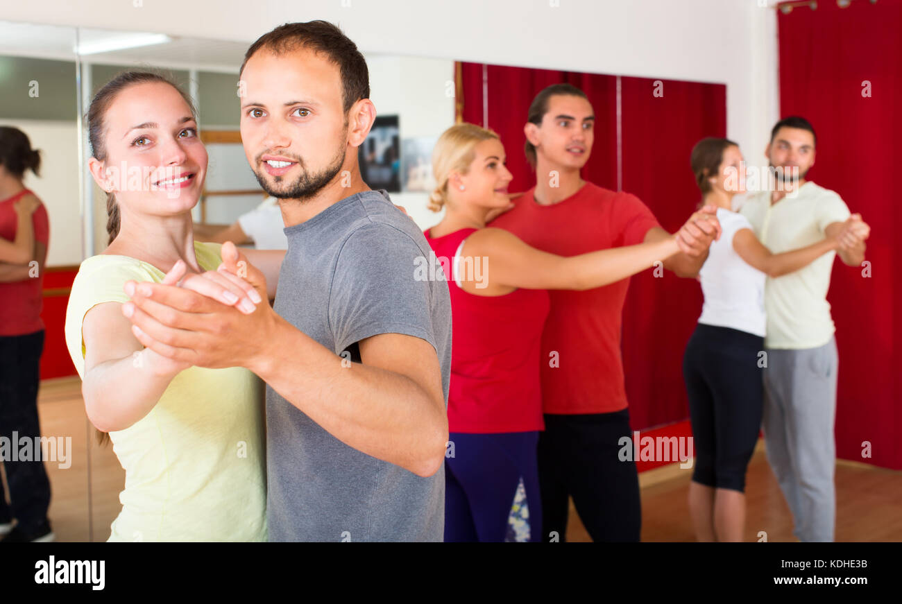 Happy pair of unprofessional dancers dancing tango in gym. Focus on man ...