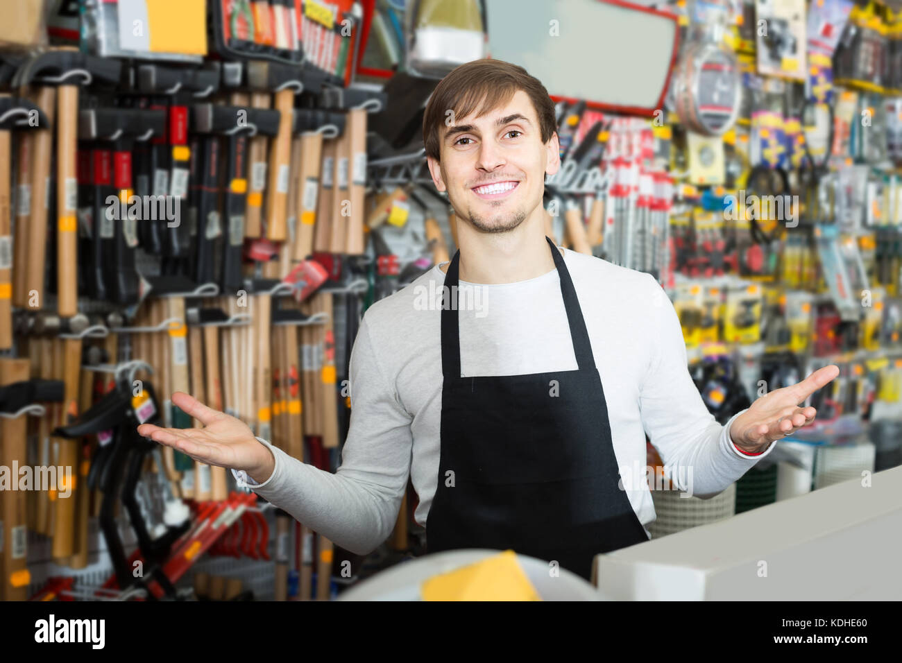Young spanish male seller posing at tooling section of household store ...