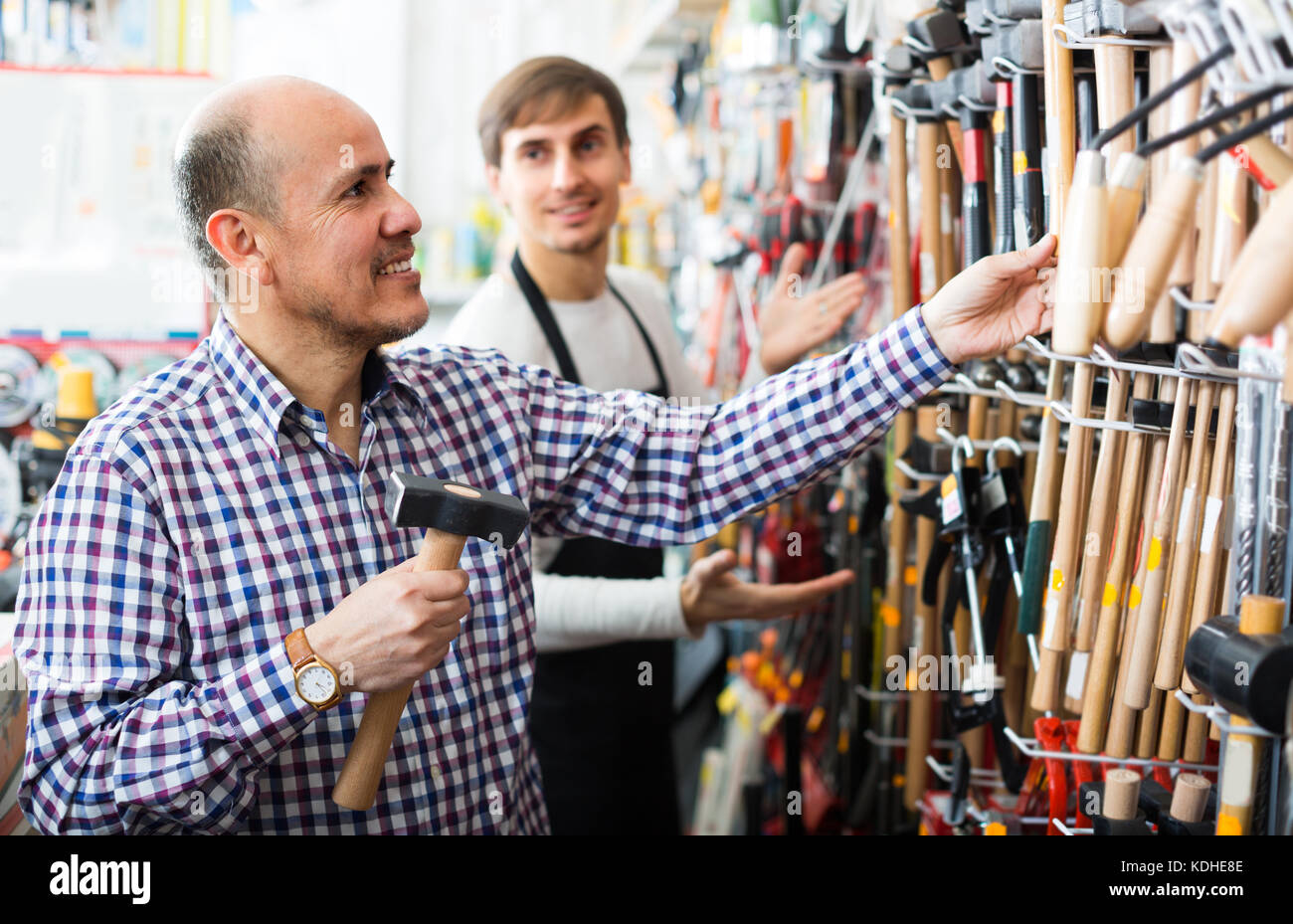 Male client and professional salesman at tooling section in building ...