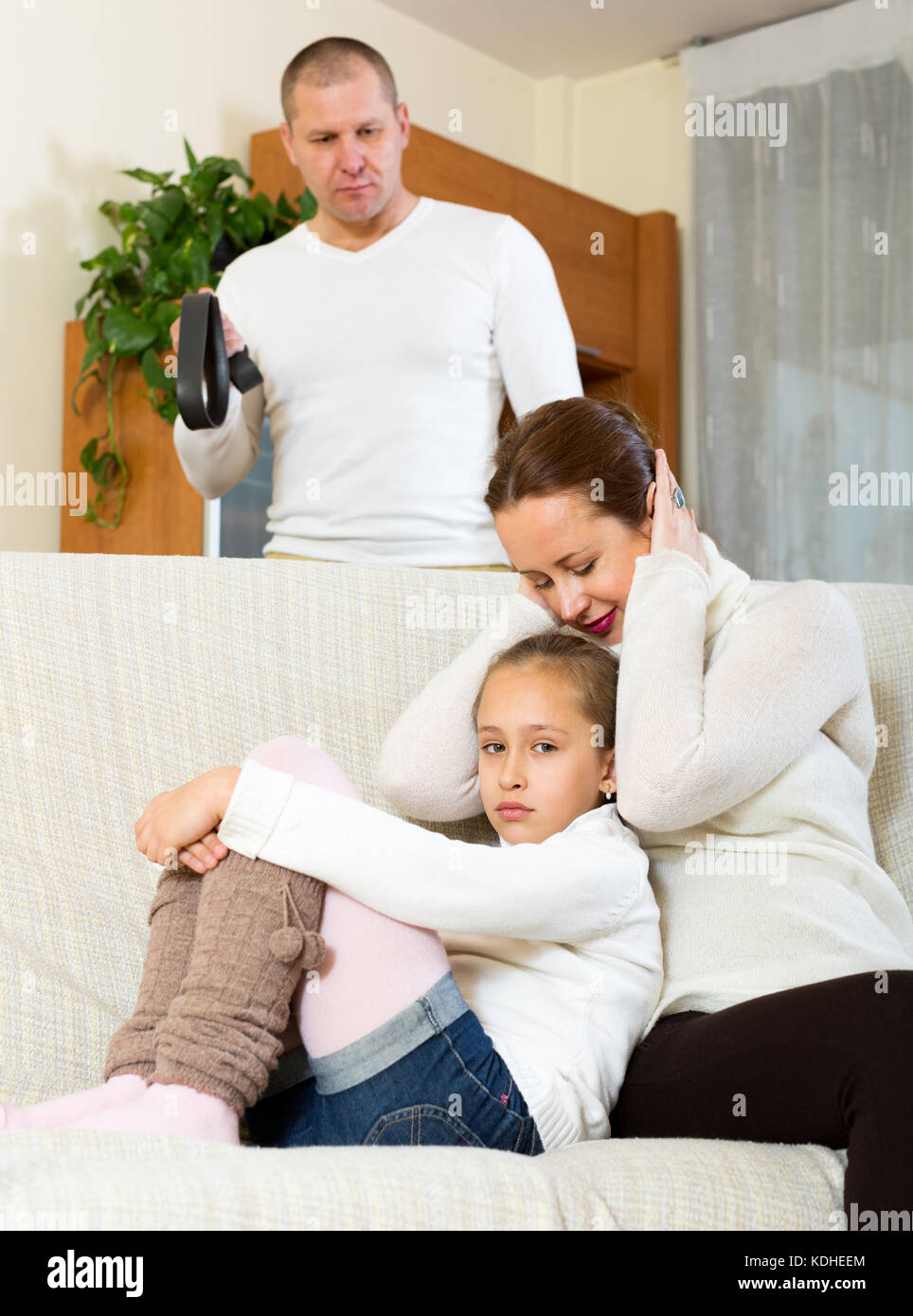 Young mother gives solace to crying daughter and angry father Stock ...