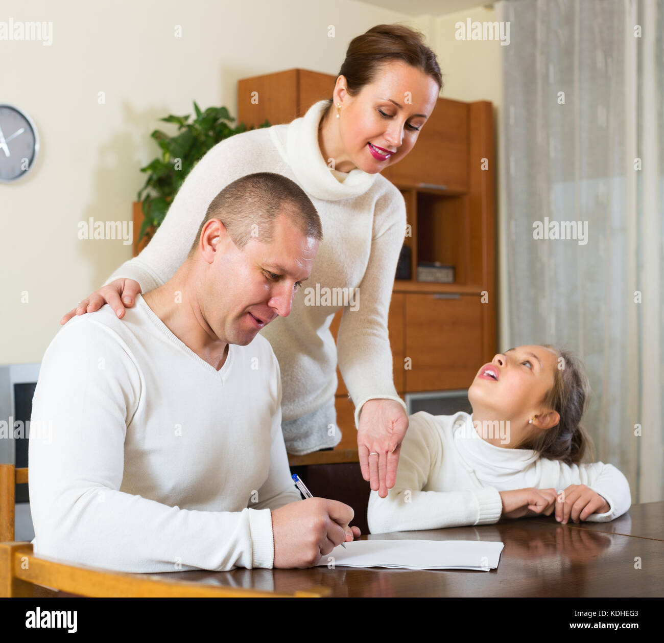 Parent and daughter answer questions of outreach worker at home Stock ...