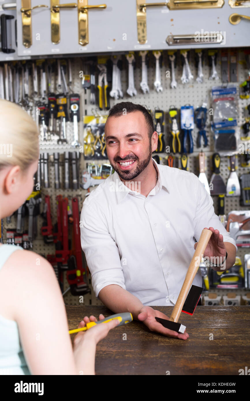 customer getting help at pay desk in household store from happy seller ...