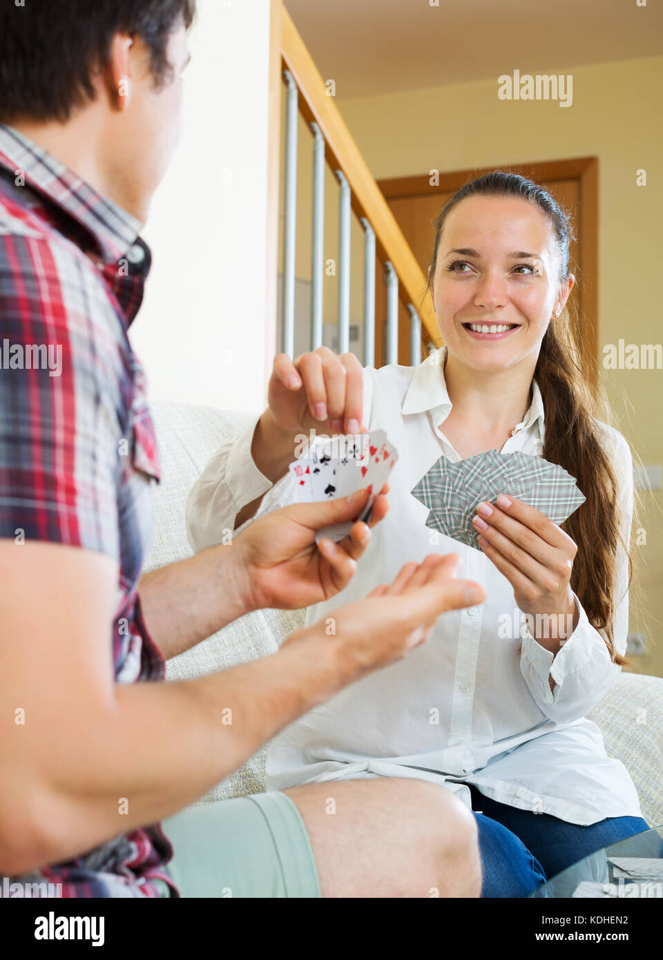 Young couple playing cards and talking in room Stock Photo - Alamy