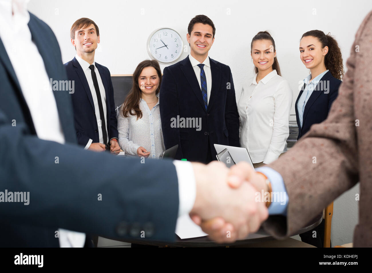 The head of office warmly greeting team member Stock Photo - Alamy