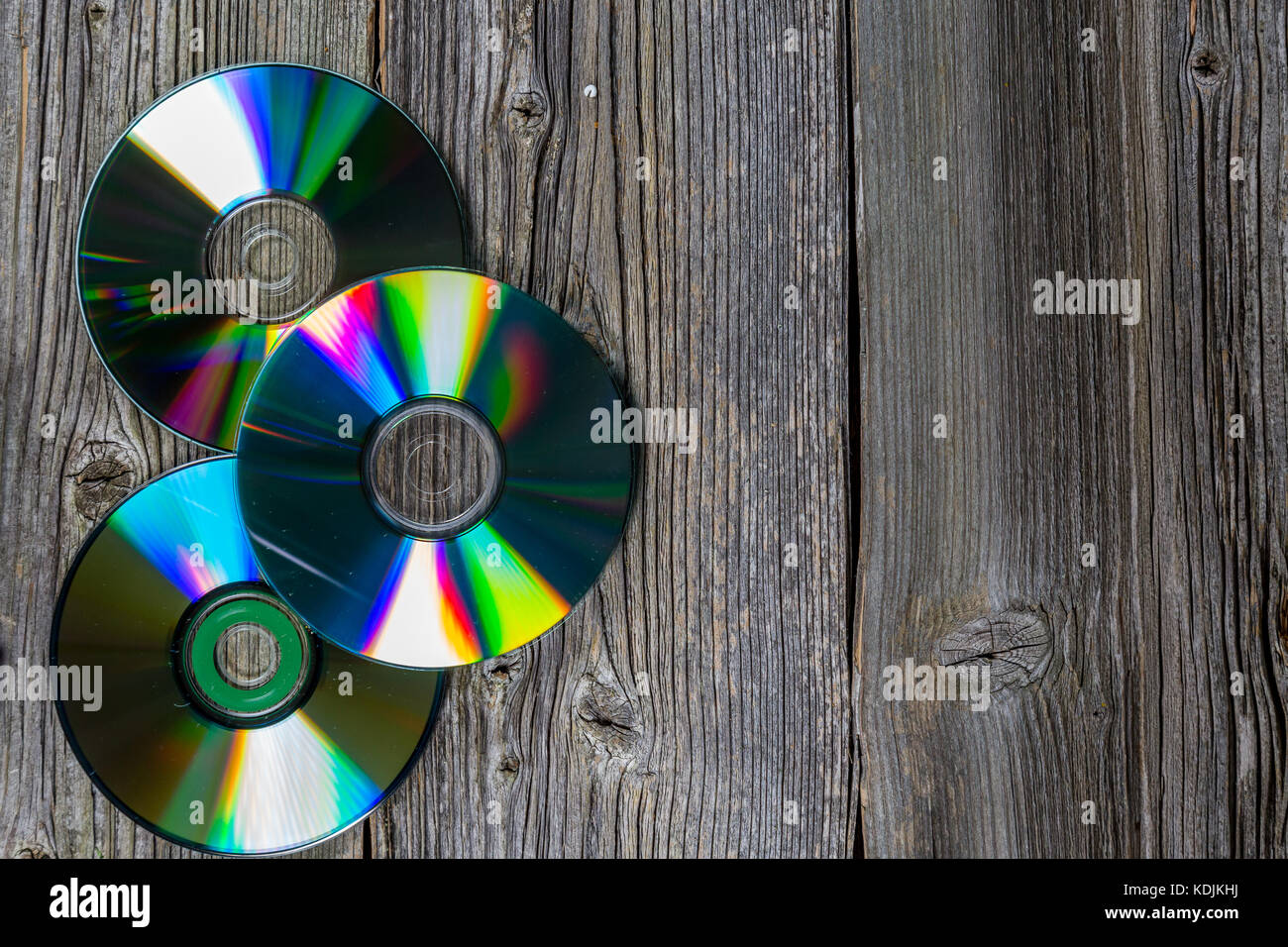 Three CD disk on dark old wooden table. Top view. Wood texture Stock ...