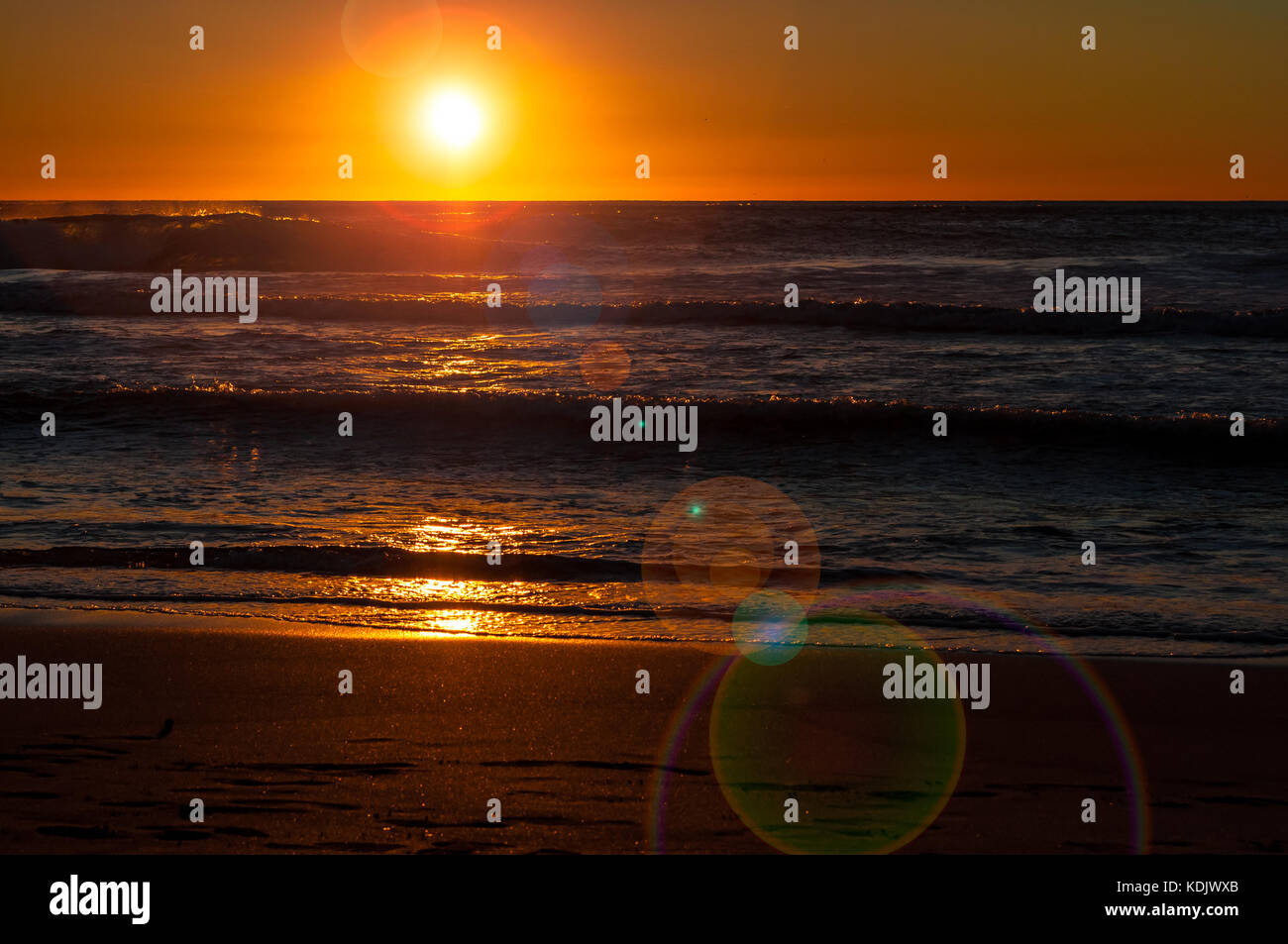 sunset on the beach in autumn with rough sea and lens flare Stock Photo ...