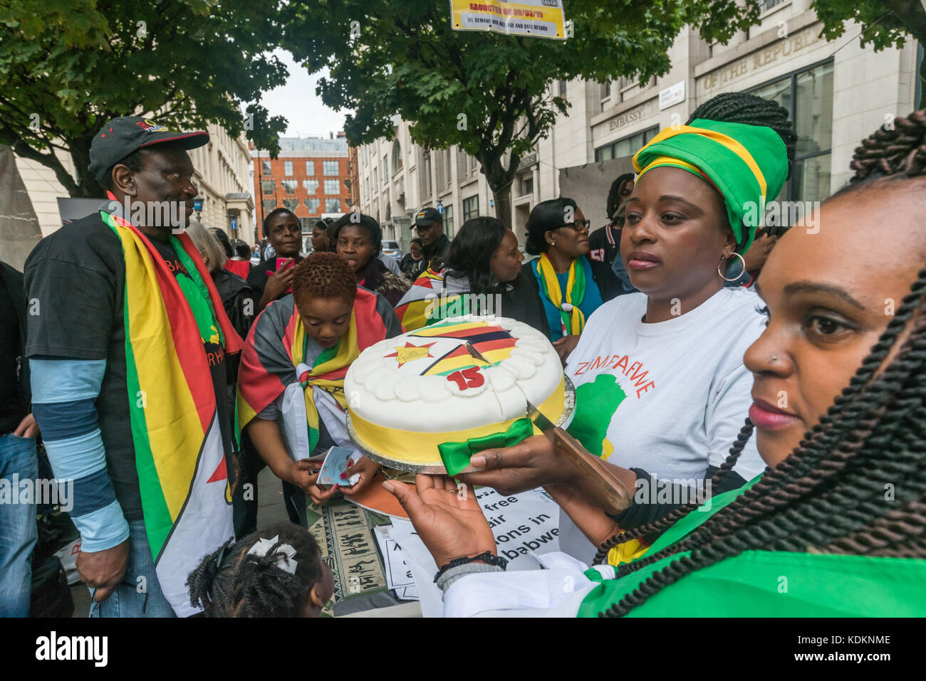 London, UK. 14th October 2017.Women hold a cake with the Zimbabwe flage ...
