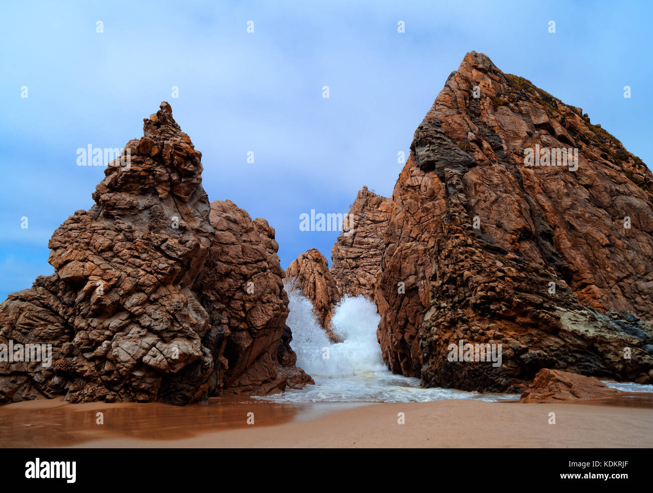 Wave passing between massive rocks Stock Photo - Alamy