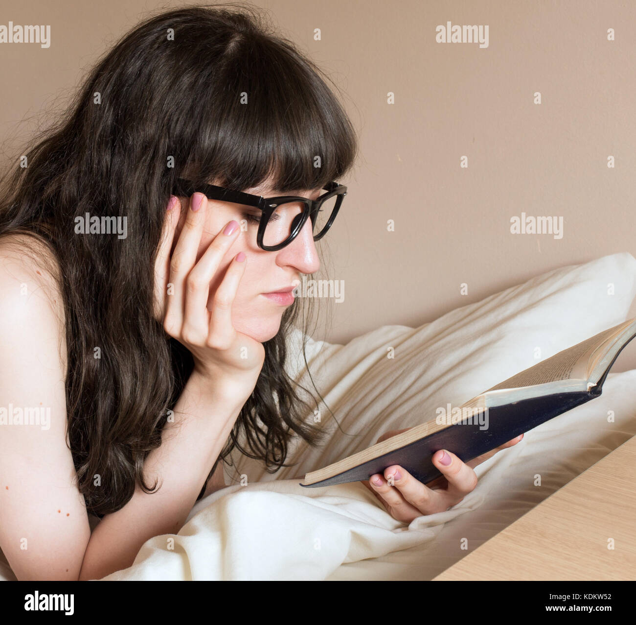 30th June 2015 - Tall girl student reading in her room Stock Photo - Alamy