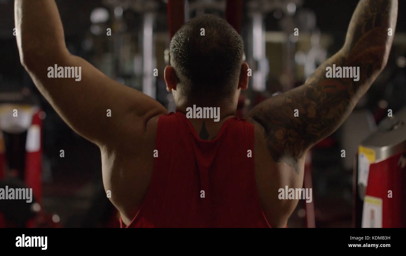 Athletic man training back muscles in gym. Brutal strong athletic men ...