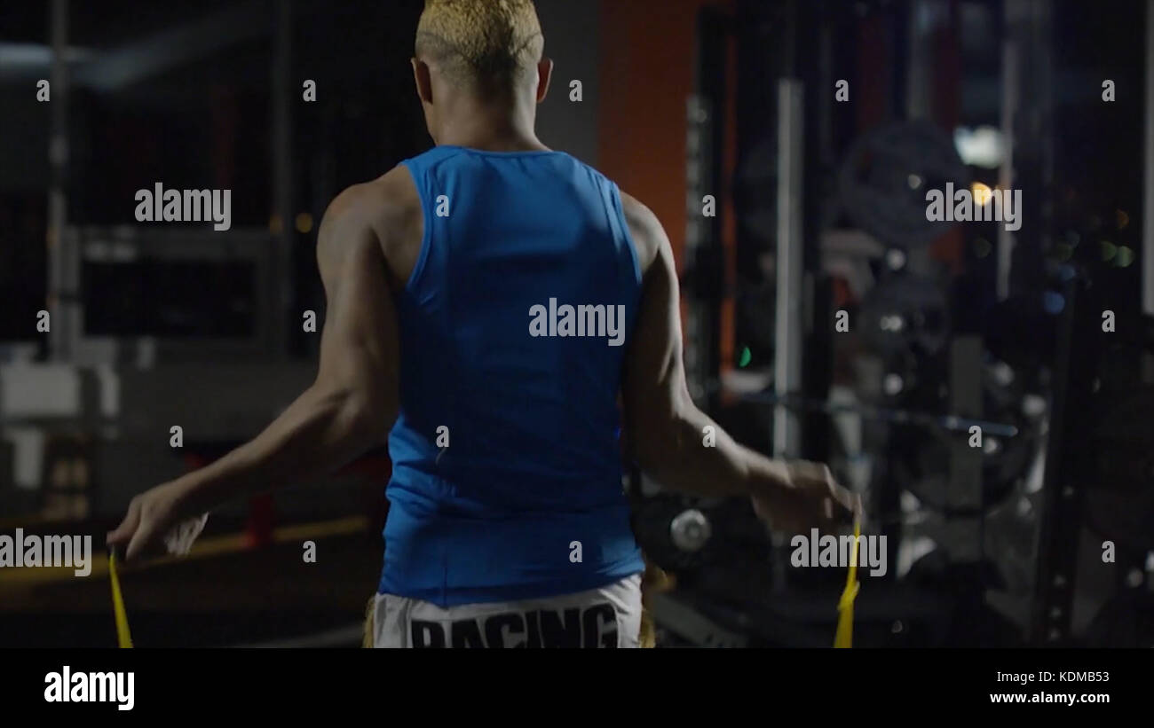 Muscular man skipping rope. Portrait of muscular young man exercising ...