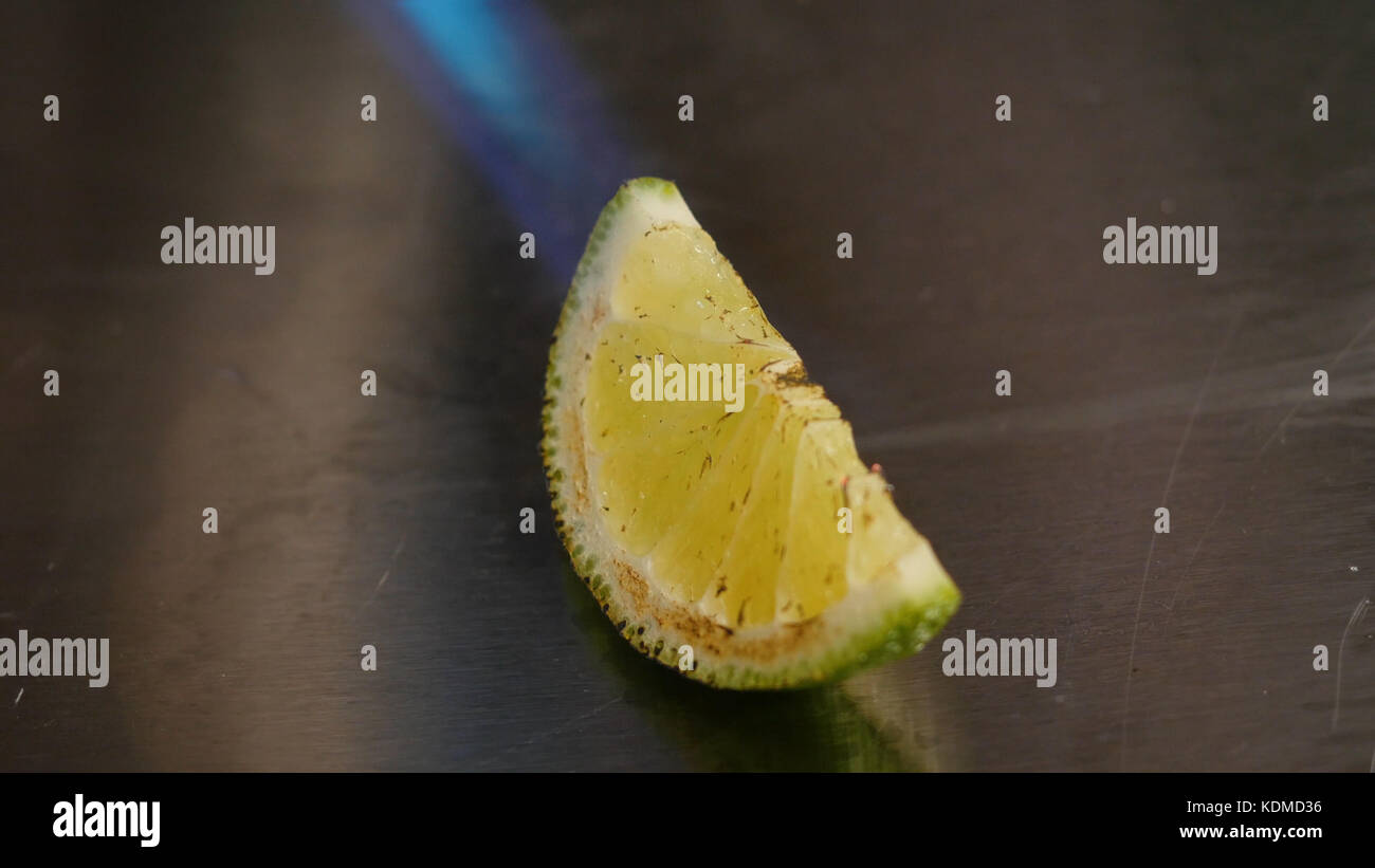 Chef burns slise of lime. Set fire to the slice of lime, lyme. Slice of ...