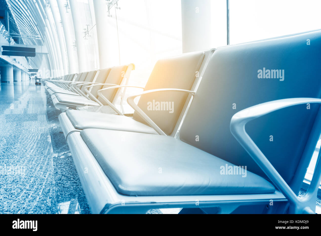 Row of leather chairs in international airport terminal at window ...
