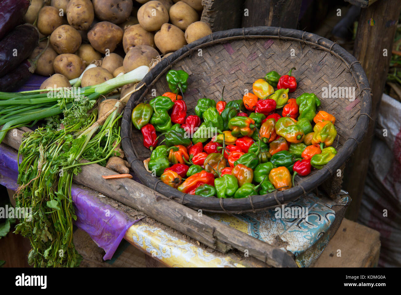 Basket of brightly coloured chillies and other vegetables for sale ...