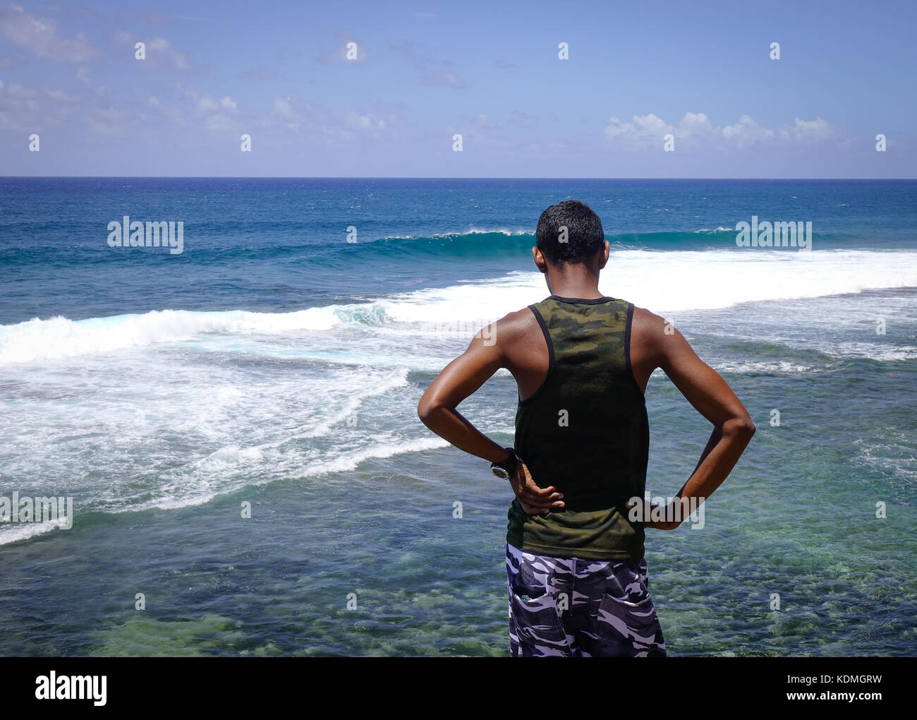 An African man looking at the sea in Le Morne, Mauritius. Mauritius is ...