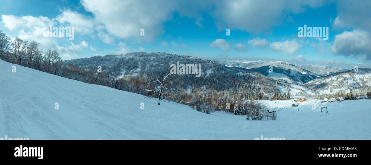 The first shadows of setting sun on winter mountain slopes with ski run ...