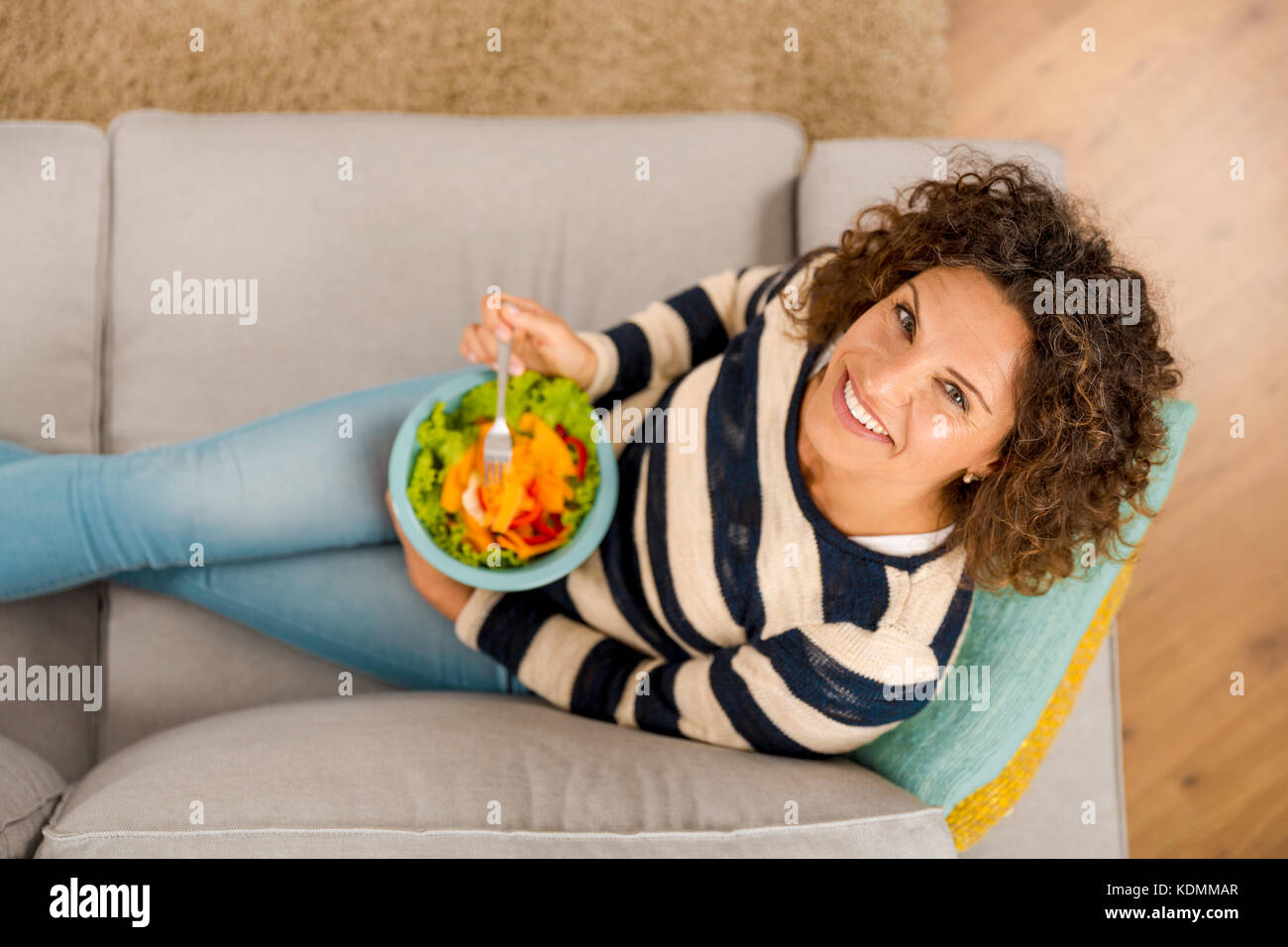Top view of a beautiful woman on the sofa eating a healthy salade Stock ...