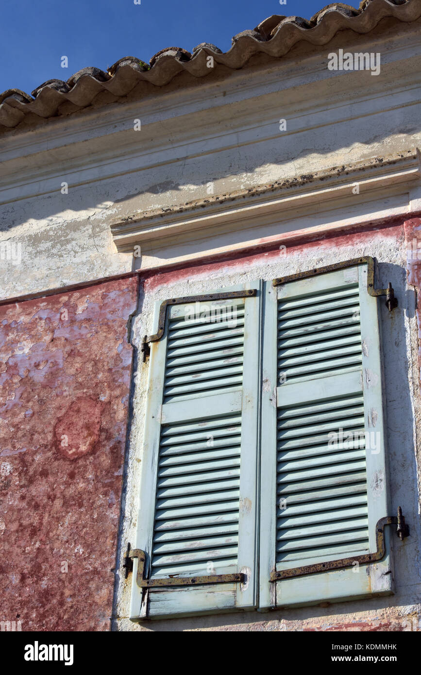 light green faded distressed painted shutters on a typically greek ...